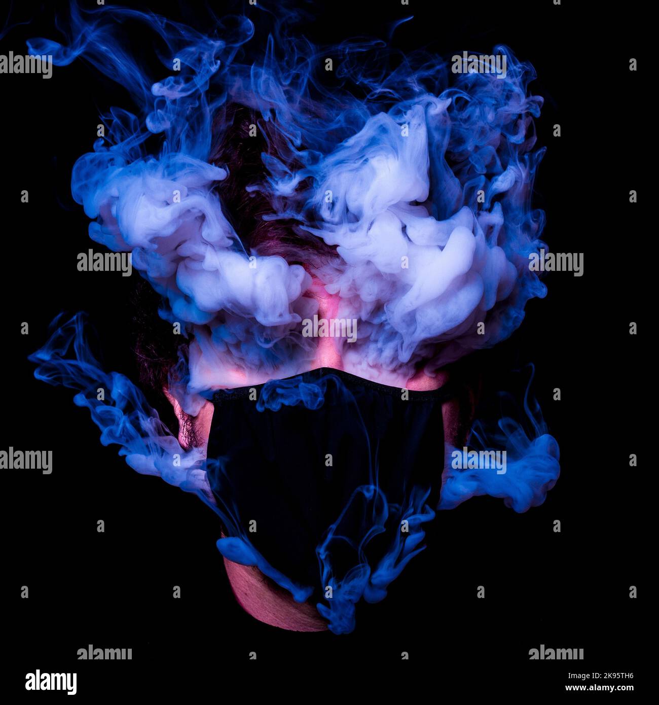 A man's face in blue smoke wearing mask on black background Stock Photo ...