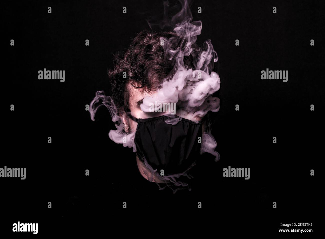 A man's face in smoke wearing mask on black background Stock Photo - Alamy