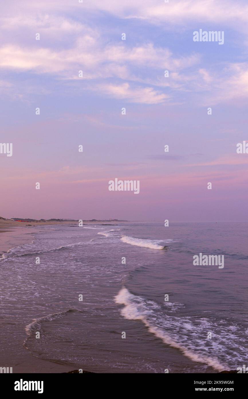 A beautiful view of tide waves on sandy beach under sunset sky ...