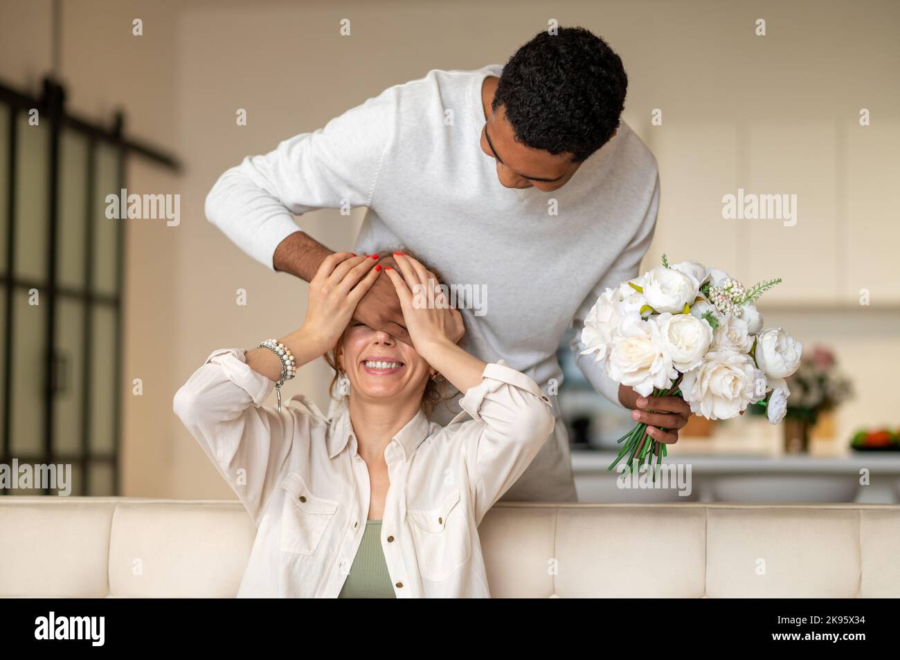 Man giving flowers to his woman and both looking happy Stock Photo - Alamy