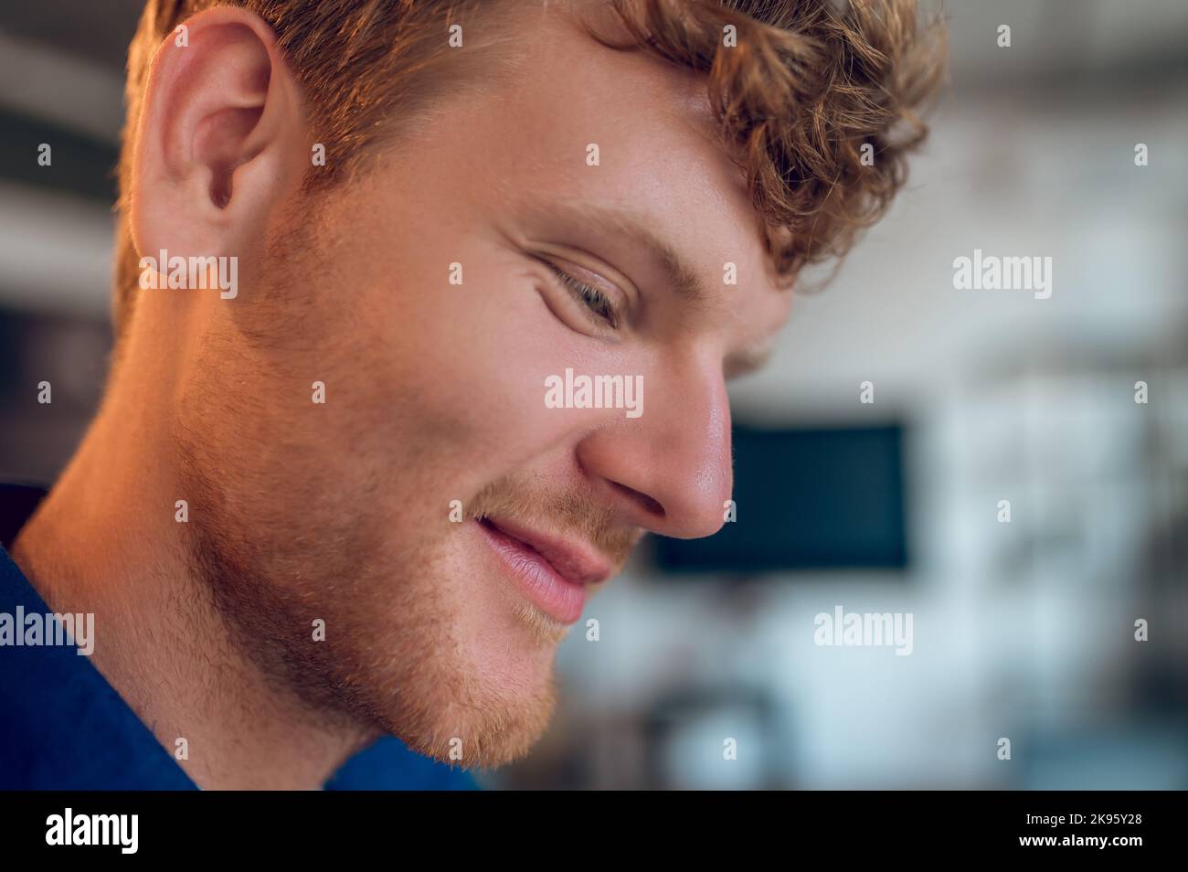 Headshot of a ginger young man looking down and smiling Stock Photo - Alamy