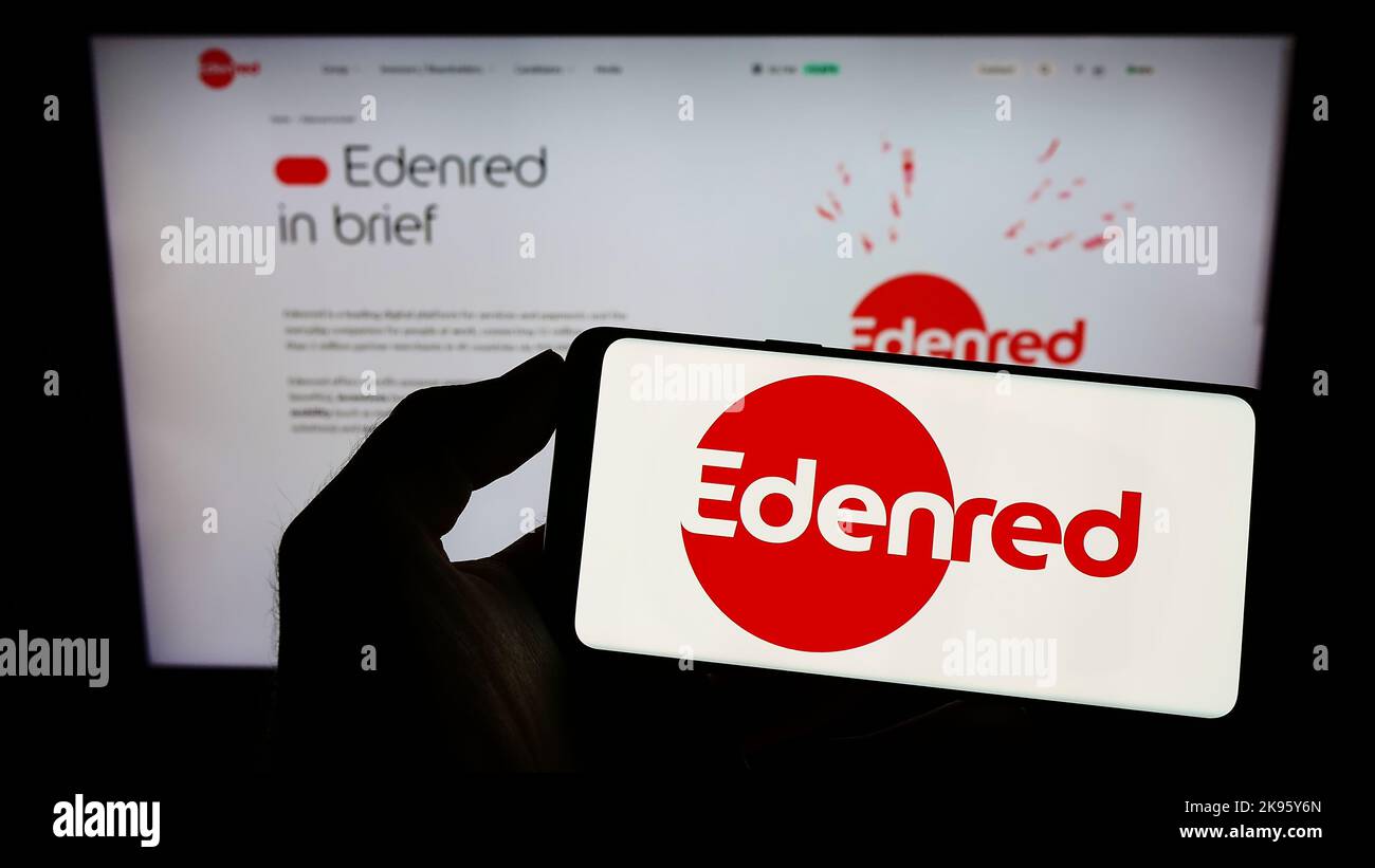 Person holding cellphone with logo of French payment solutions company ...