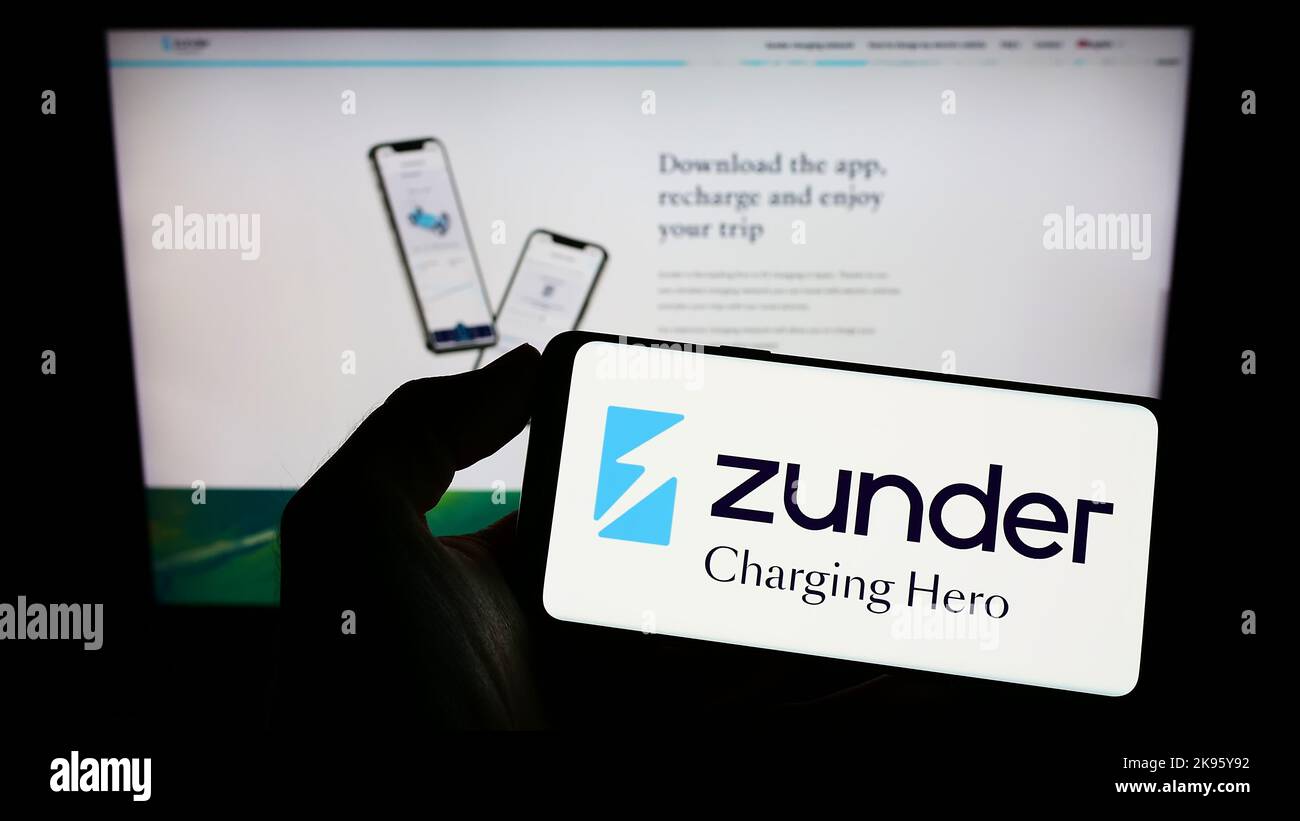 Person holding mobile phone with logo of Spanish company Grupo ...