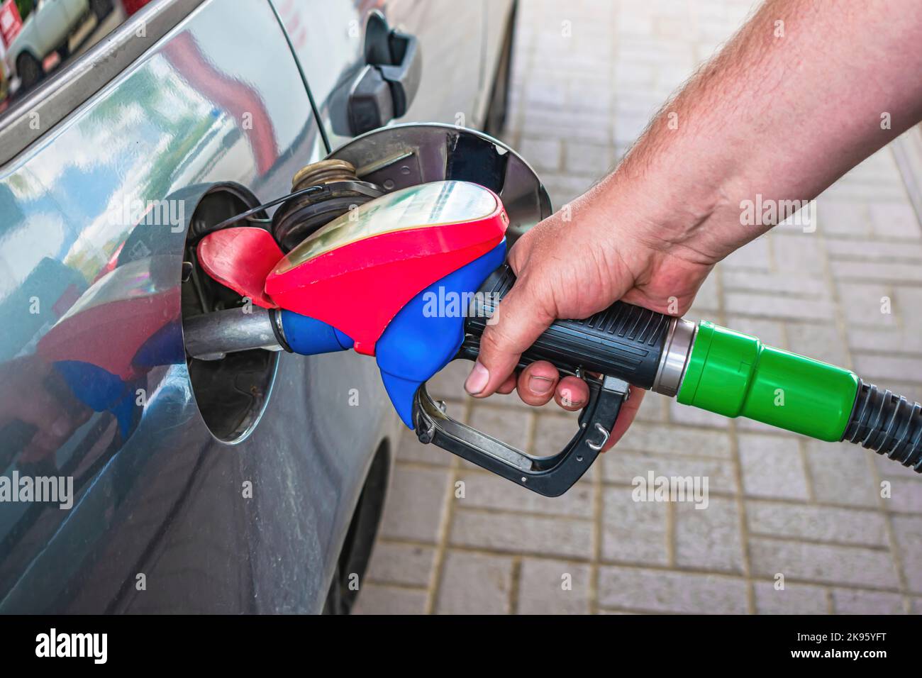 The driver fills up expensive gasoline in the fuel tank of the car ...