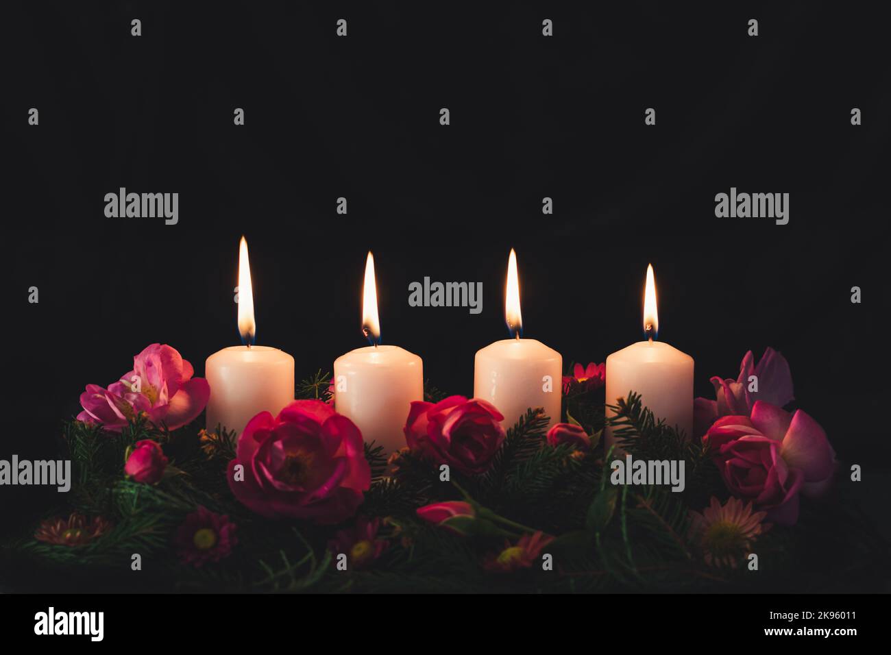 fourth burning advent candle on decorated rose flower pink advent ...