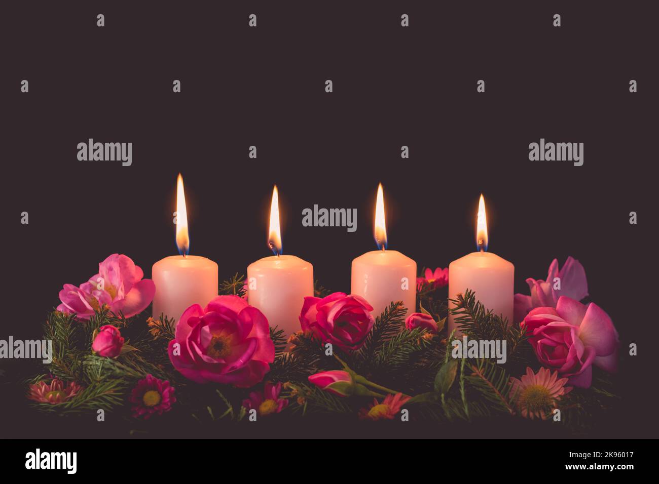 fourth burning advent candle on decorated rose flower pink advent ...