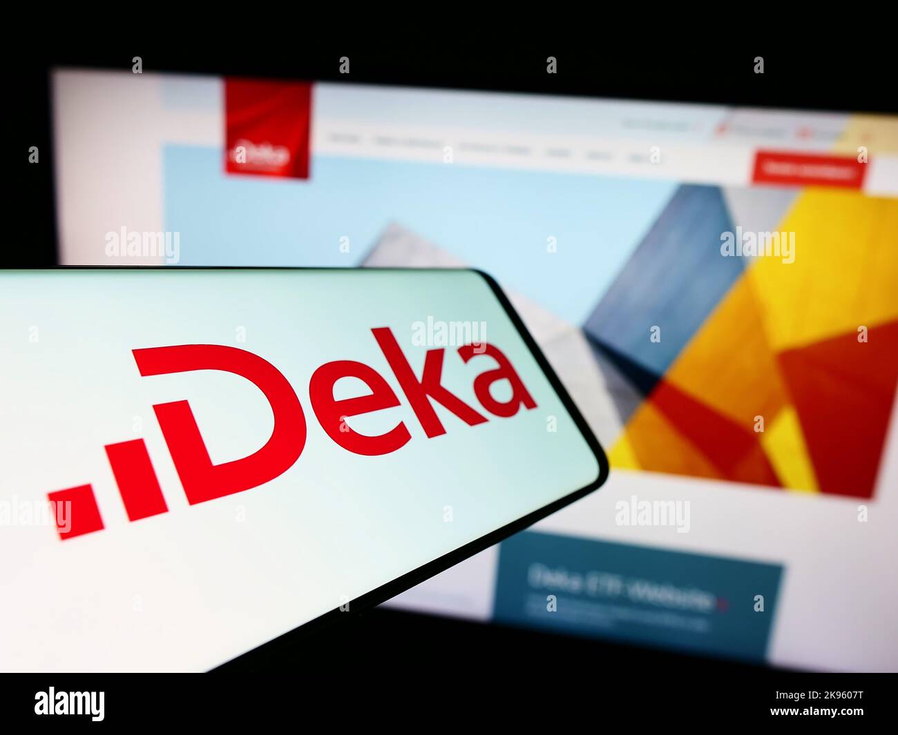 Mobile phone with logo of DekaBank Deutsche Girozentrale on screen in front of company website ...