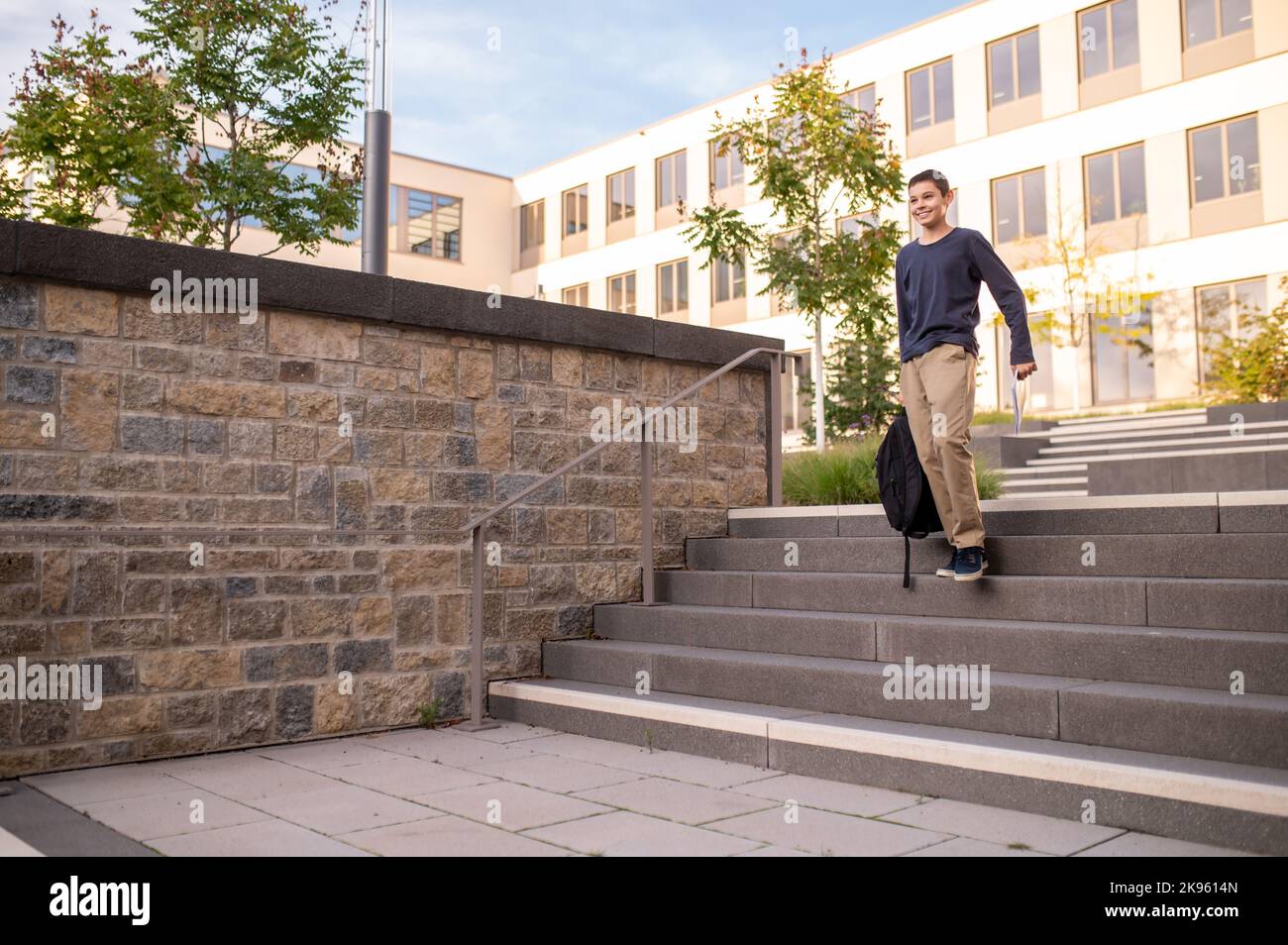 Cheerful schoolboy walking down the concrete steps Stock Photo - Alamy