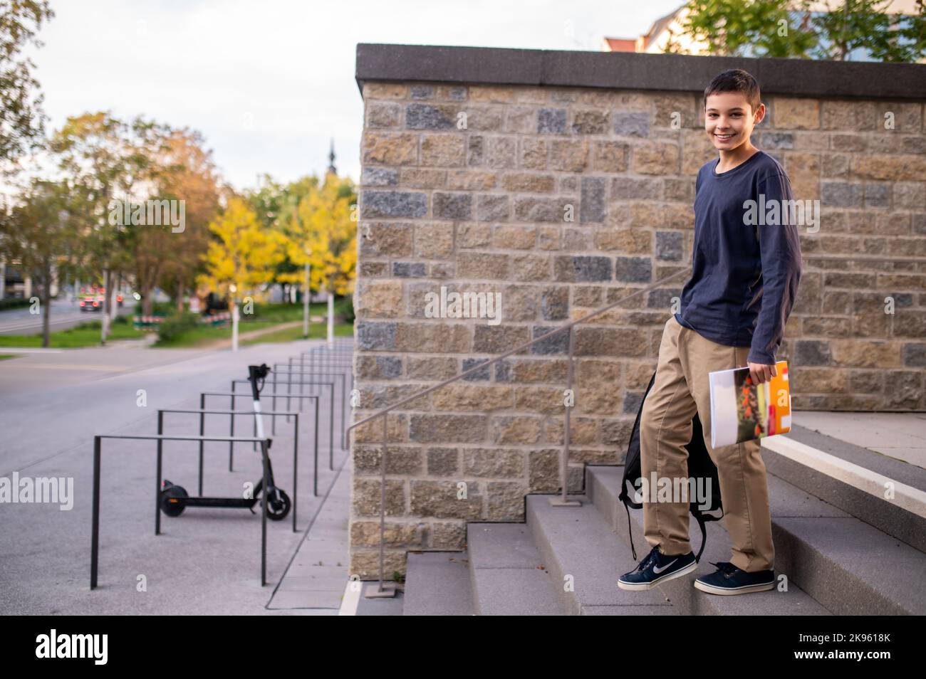 Smiling adolescent boy walking down the steps Stock Photo - Alamy
