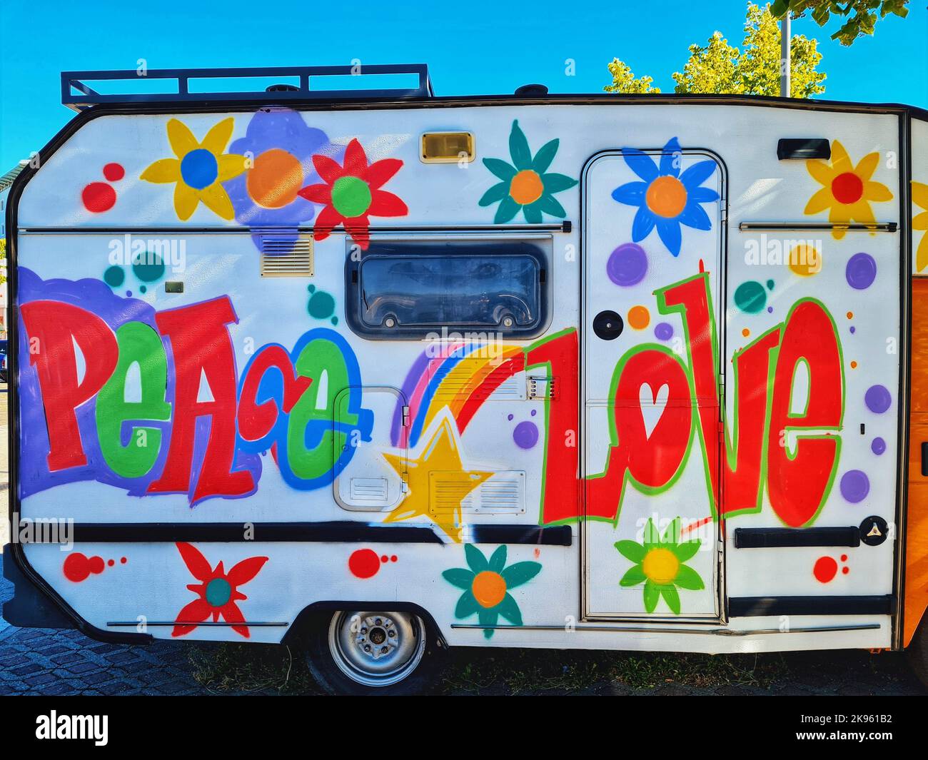 A colorful camper with flowers and the text ''peace and love'' on the ...