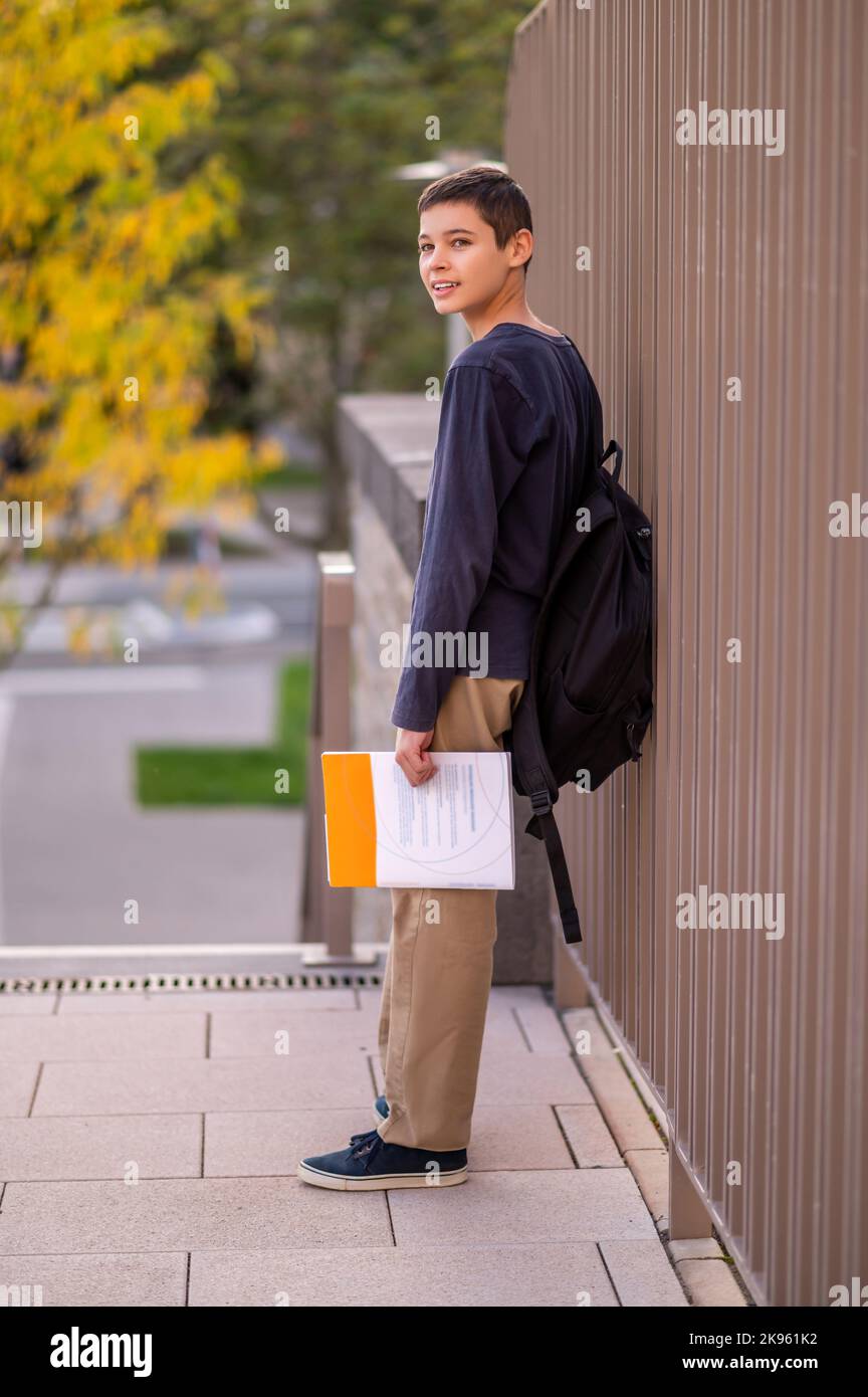 Cute dark-haired adolescent boy standing alone outdoors Stock Photo - Alamy