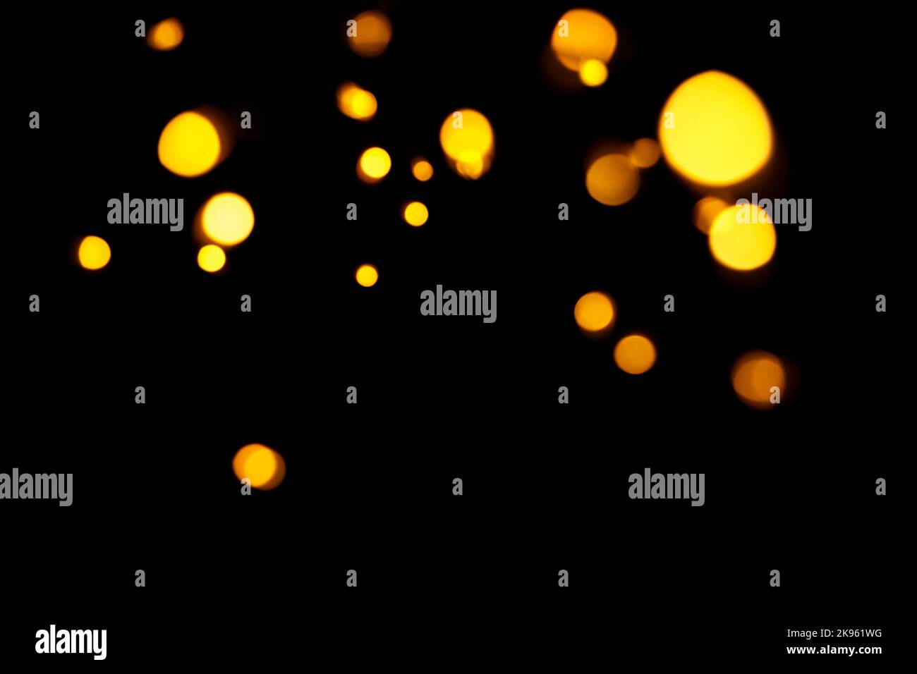 Gold bokeh on dark background. Defocused golden lights. New Year ...