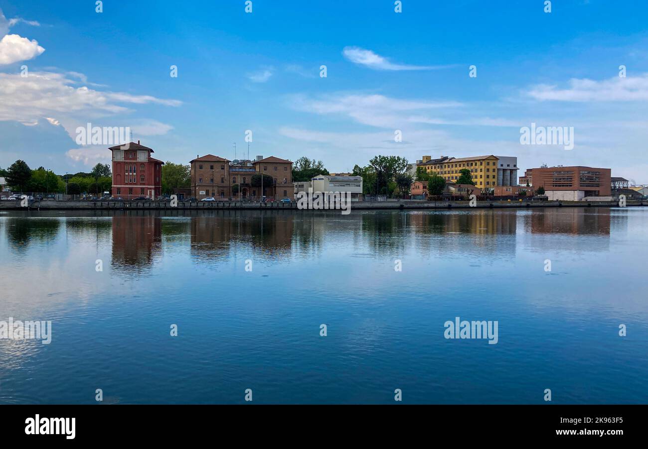 An aerial view of dock surrounded by buildings with reflection in water ...