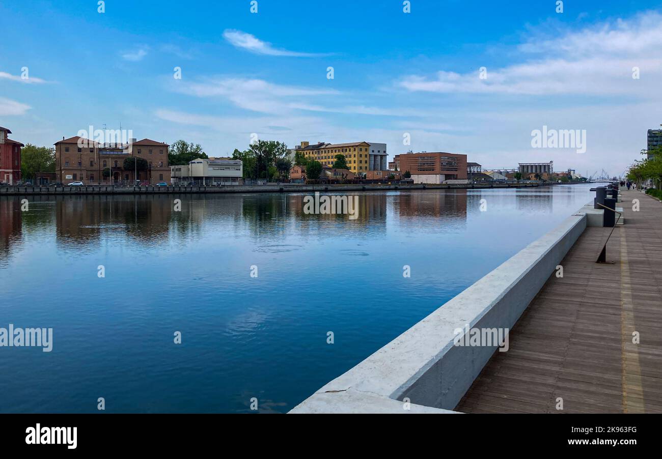 An aerial view of dock surrounded by buildings with reflection in water ...