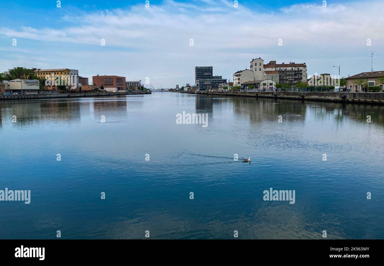 An aerial view of dock surrounded by buildings with reflection in water ...