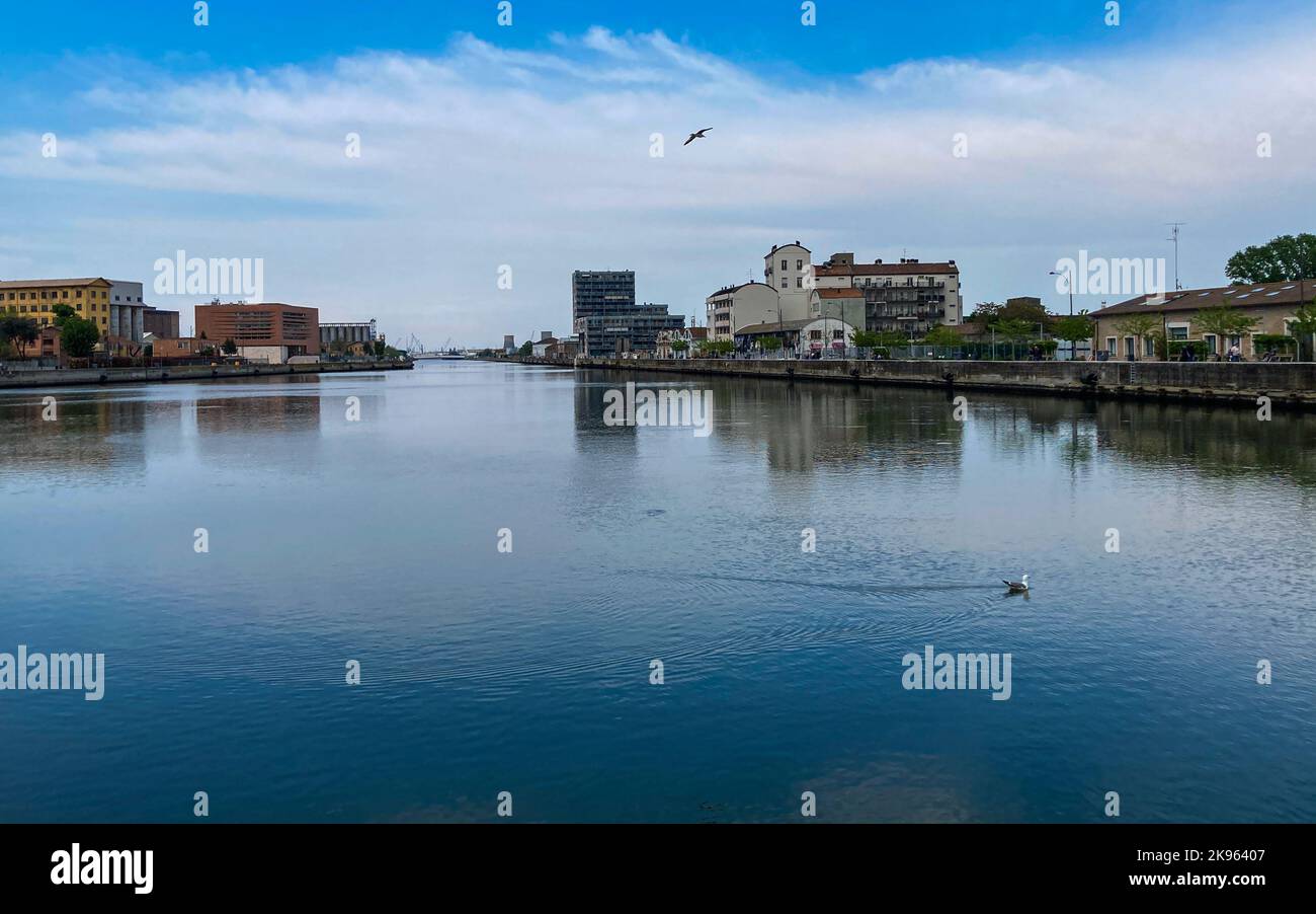 An aerial view of dock surrounded by buildings with reflection in water ...