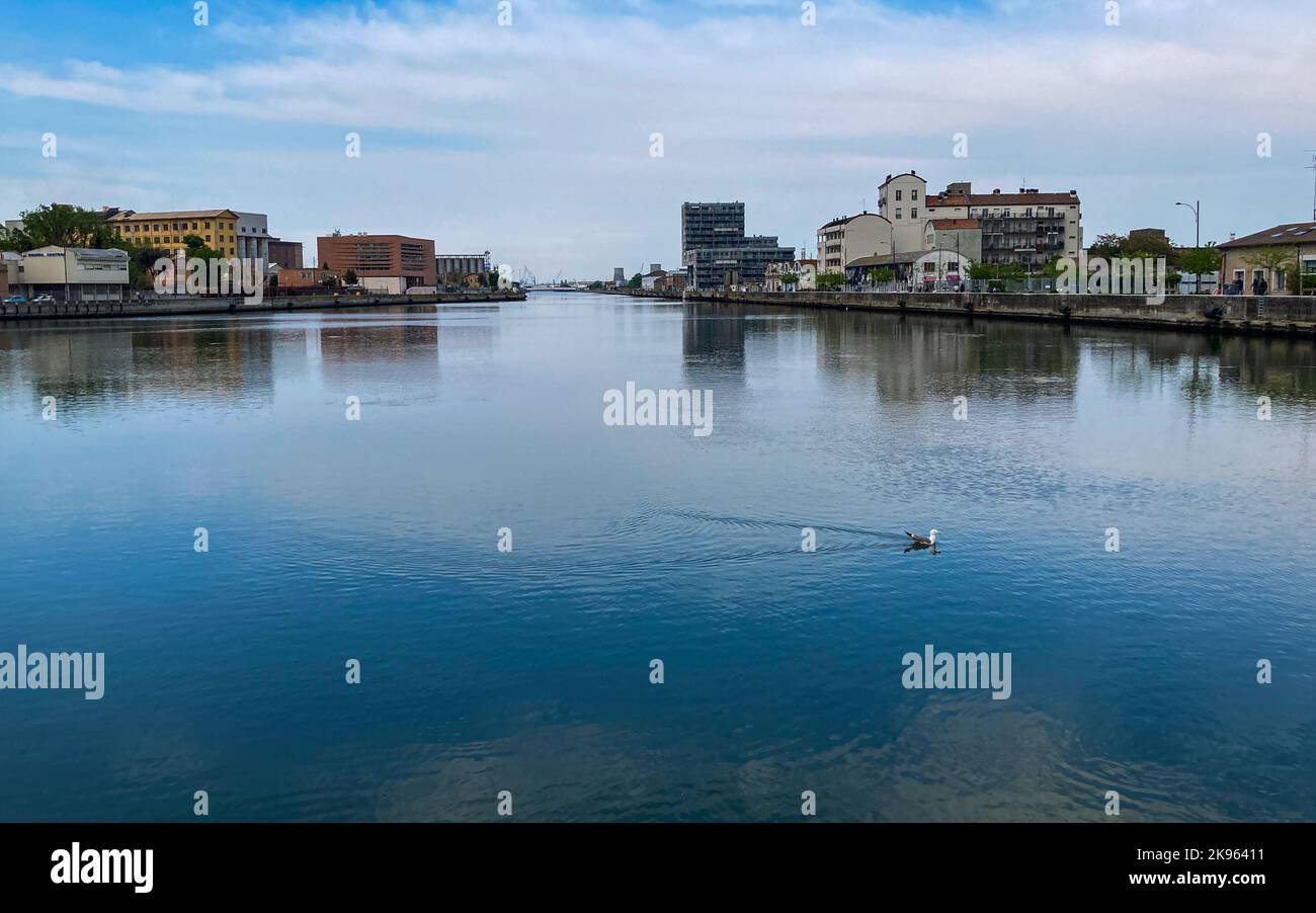 An aerial view of dock surrounded by buildings with reflection in water ...