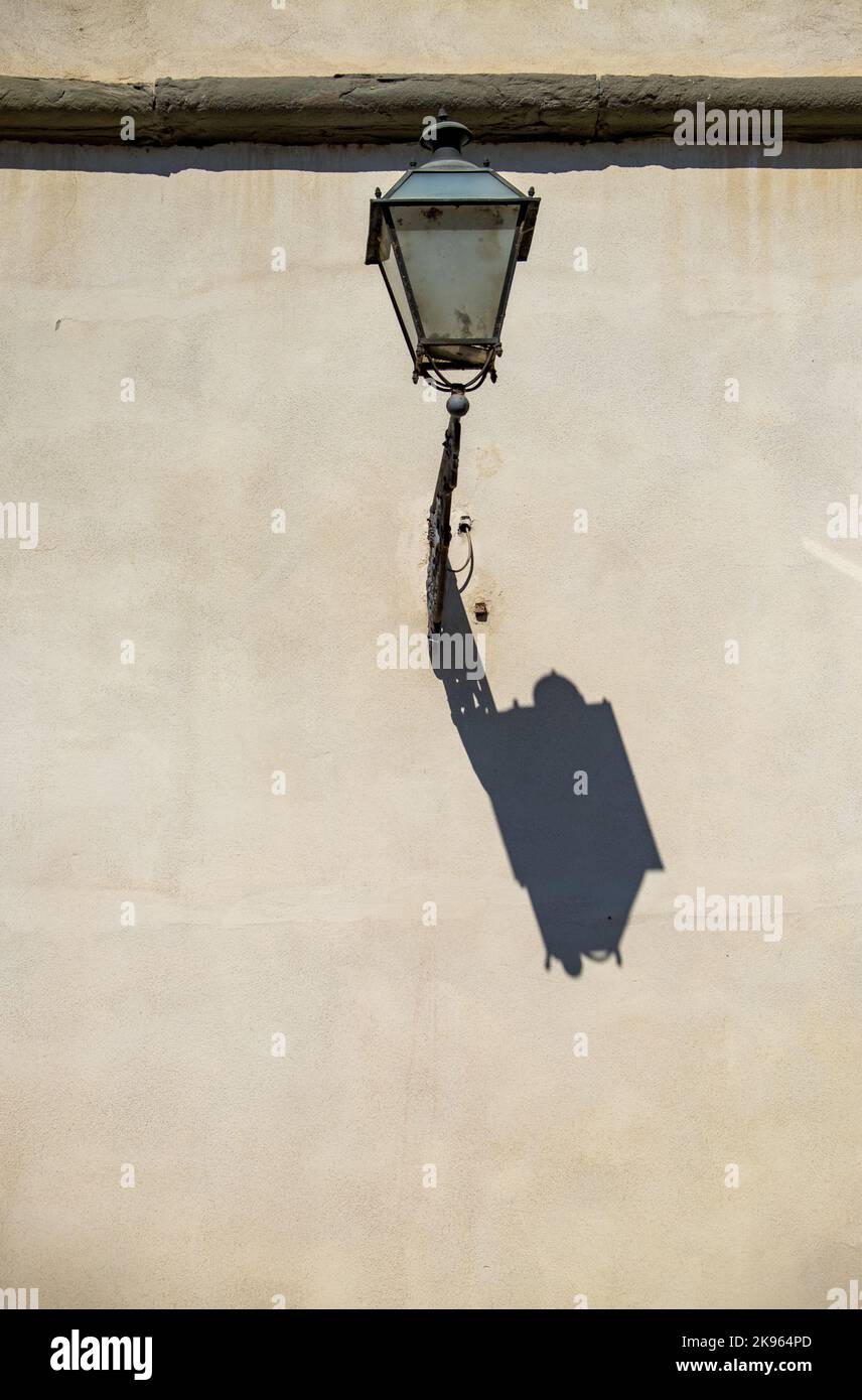 Italian street lamp in bright sunshine withd shadow in Lucca, Italy ...