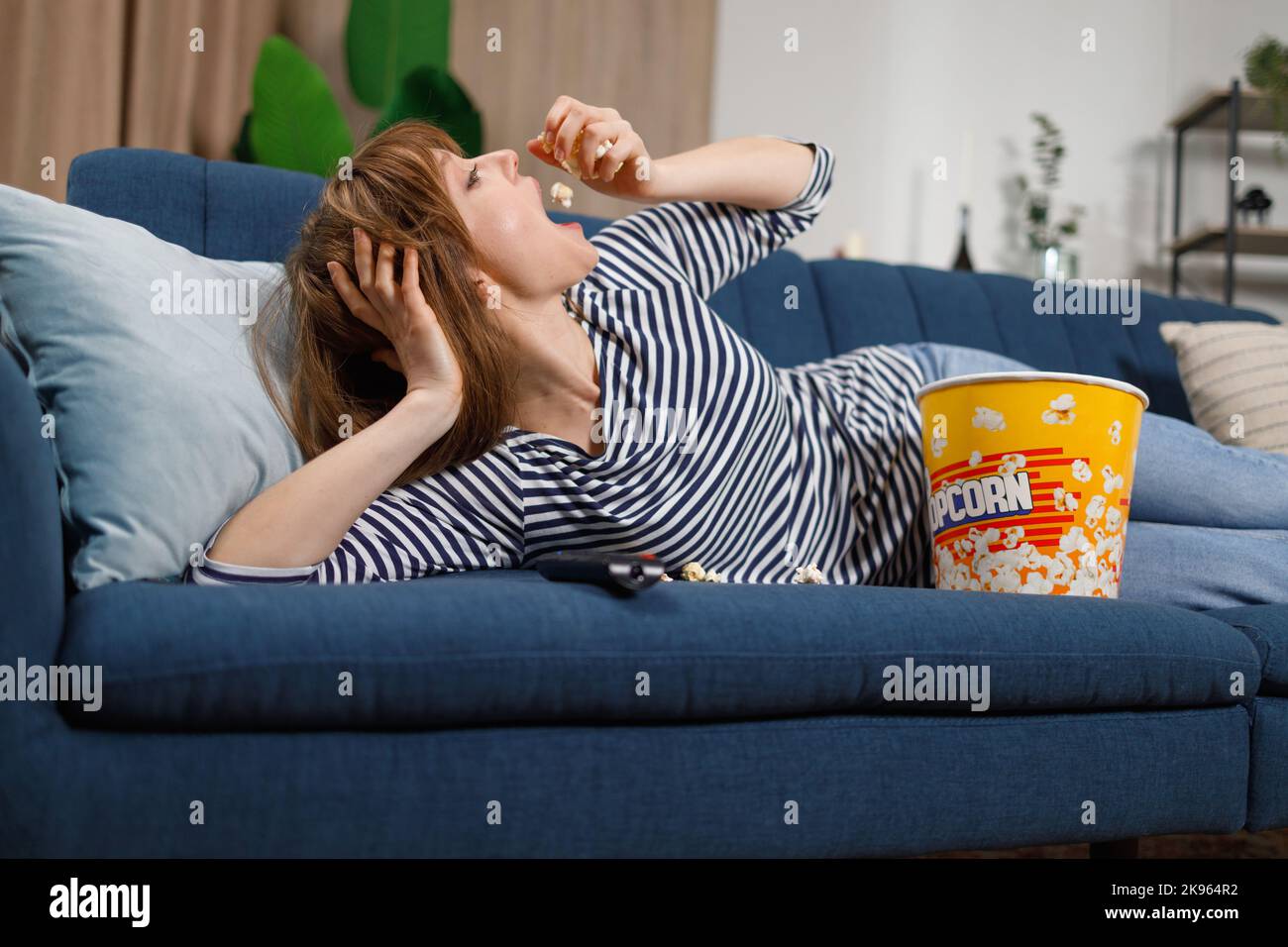 Woman lying on couch eating hi-res stock photography and images - Alamy