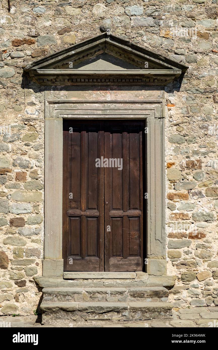 Wooden doors set in a stone wall with a pediment in Pontremoli, Tuscany ...