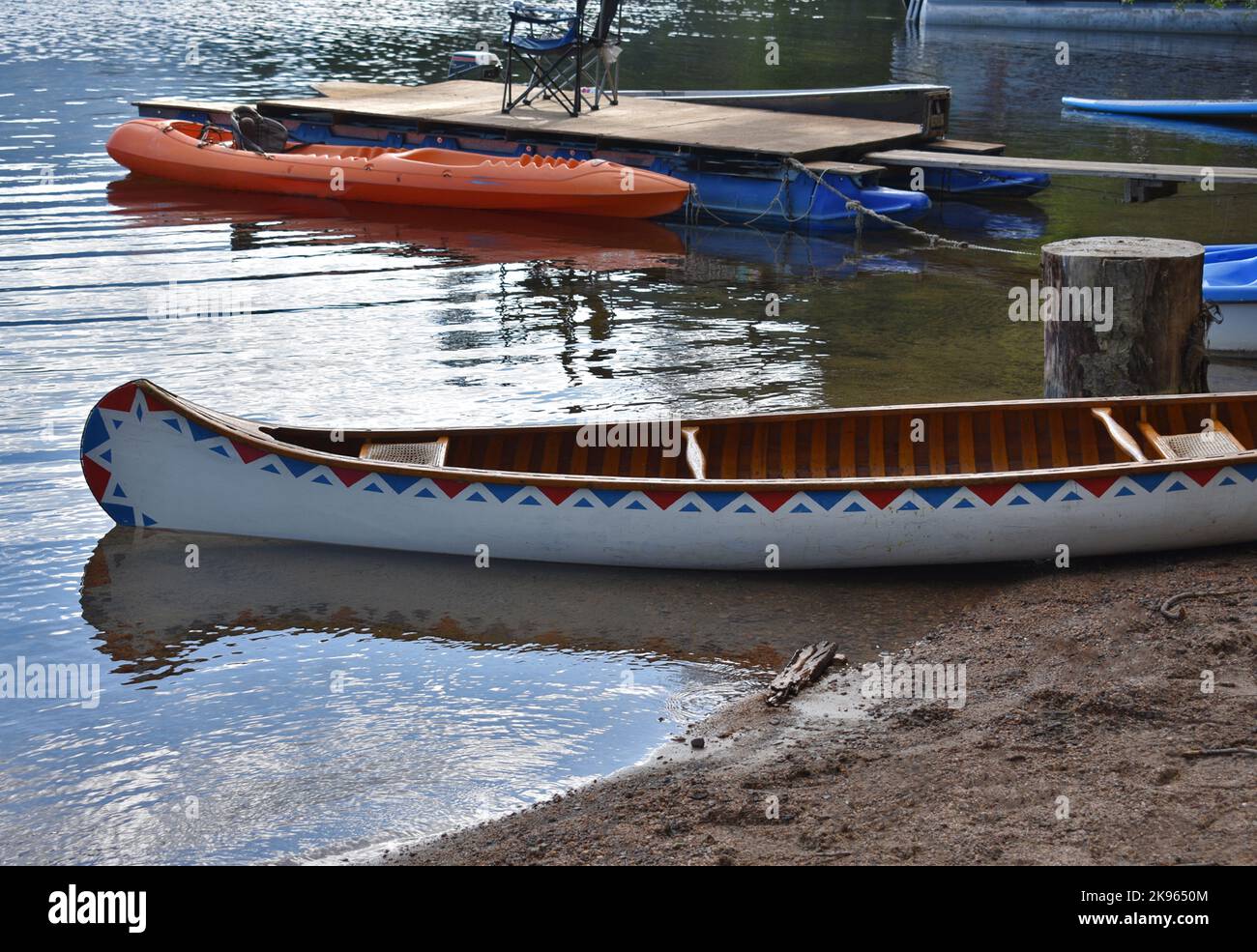 A beautiful vintage canoe on a lake shore on the surface of the glassy ...