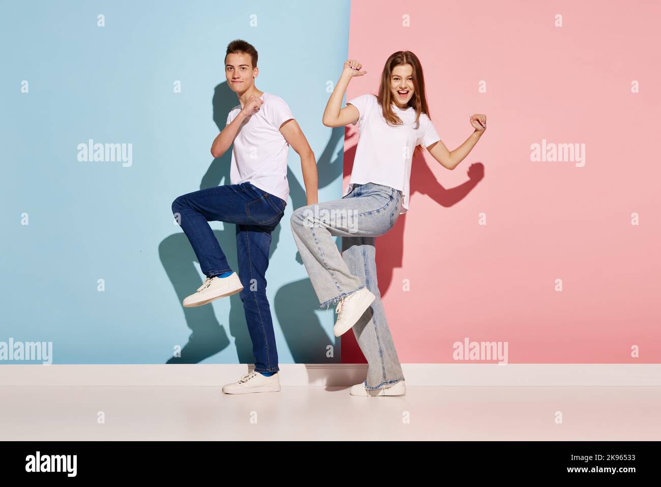 Portrait of young people, man and woman in casual clothes dancing ...