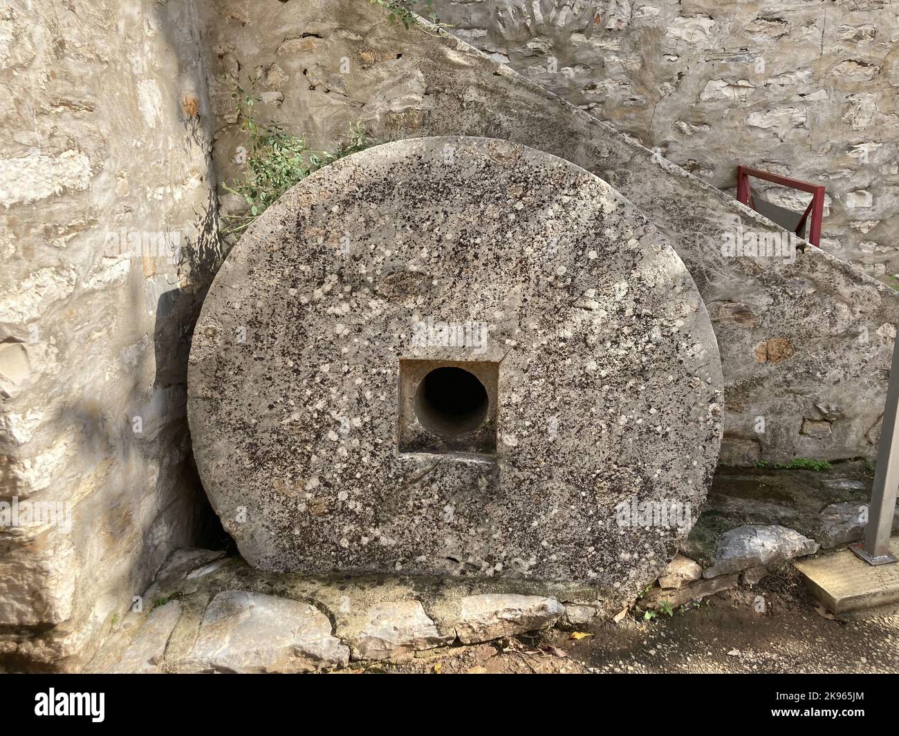 An old olive grinding stone with a hole in the center Stock Photo - Alamy