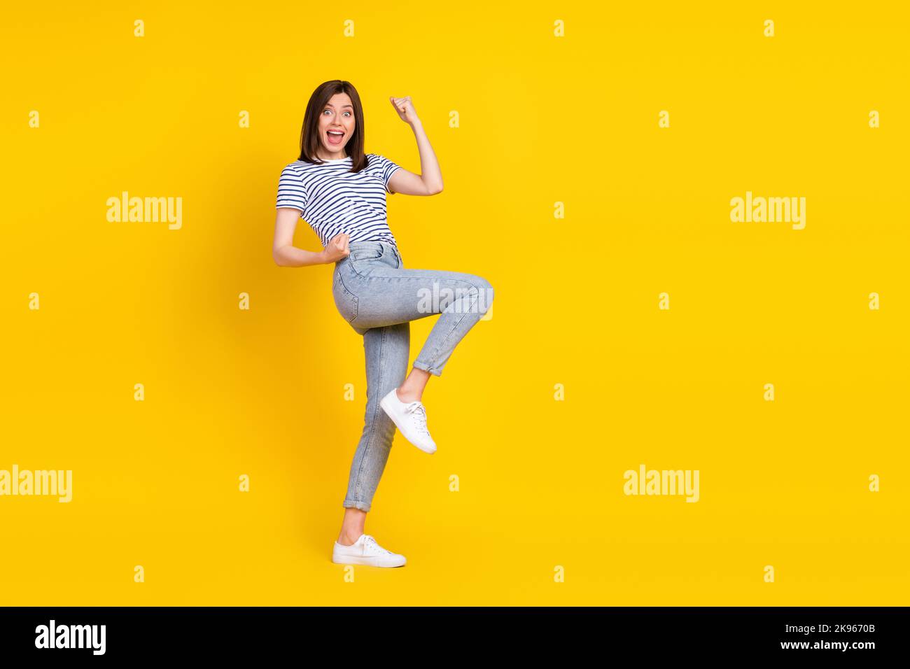 Photo of satisfied overjoyed lady raise arm leg rejoice yeap stand ...