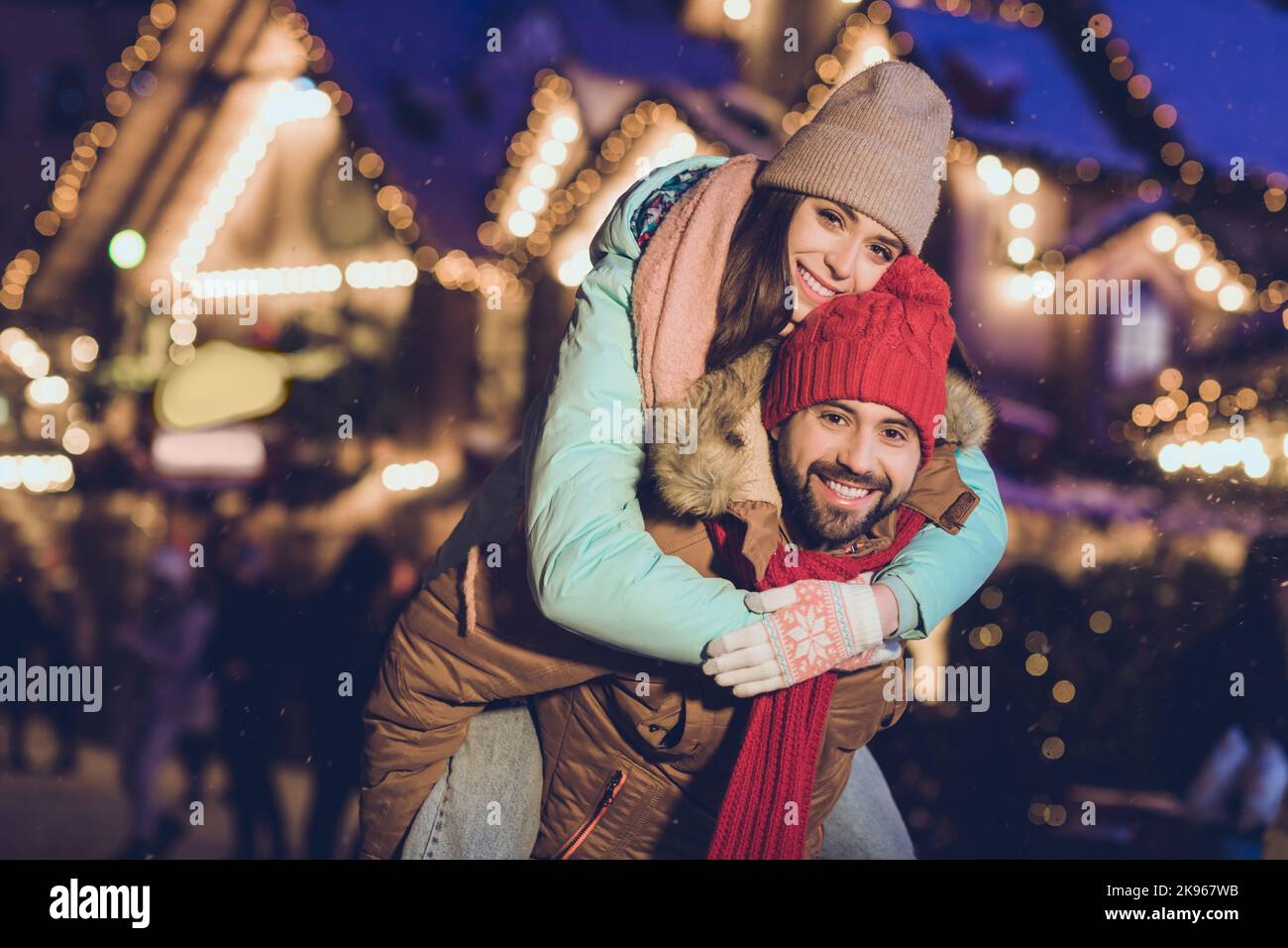 Photo of beautiful lovers young couple piggyback hug wear cap jacket ...