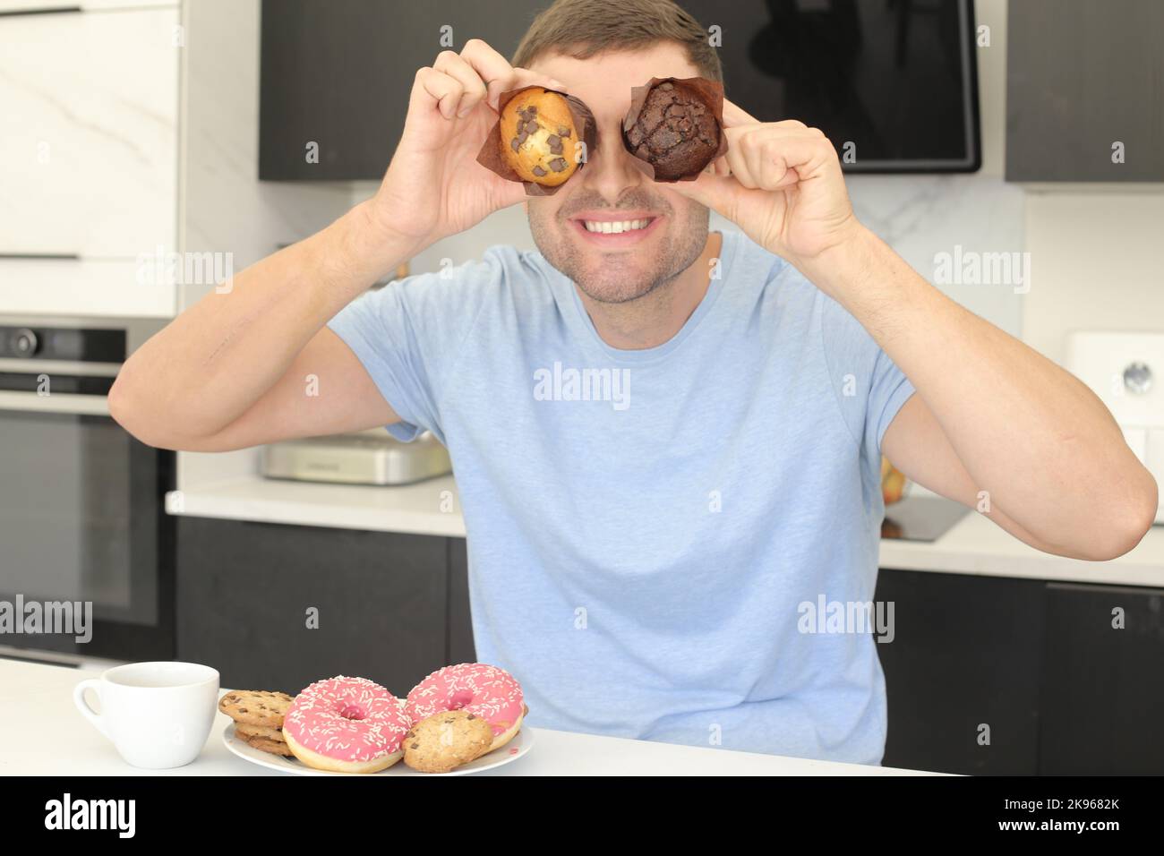 Man with muffins covering eyes Stock Photo - Alamy
