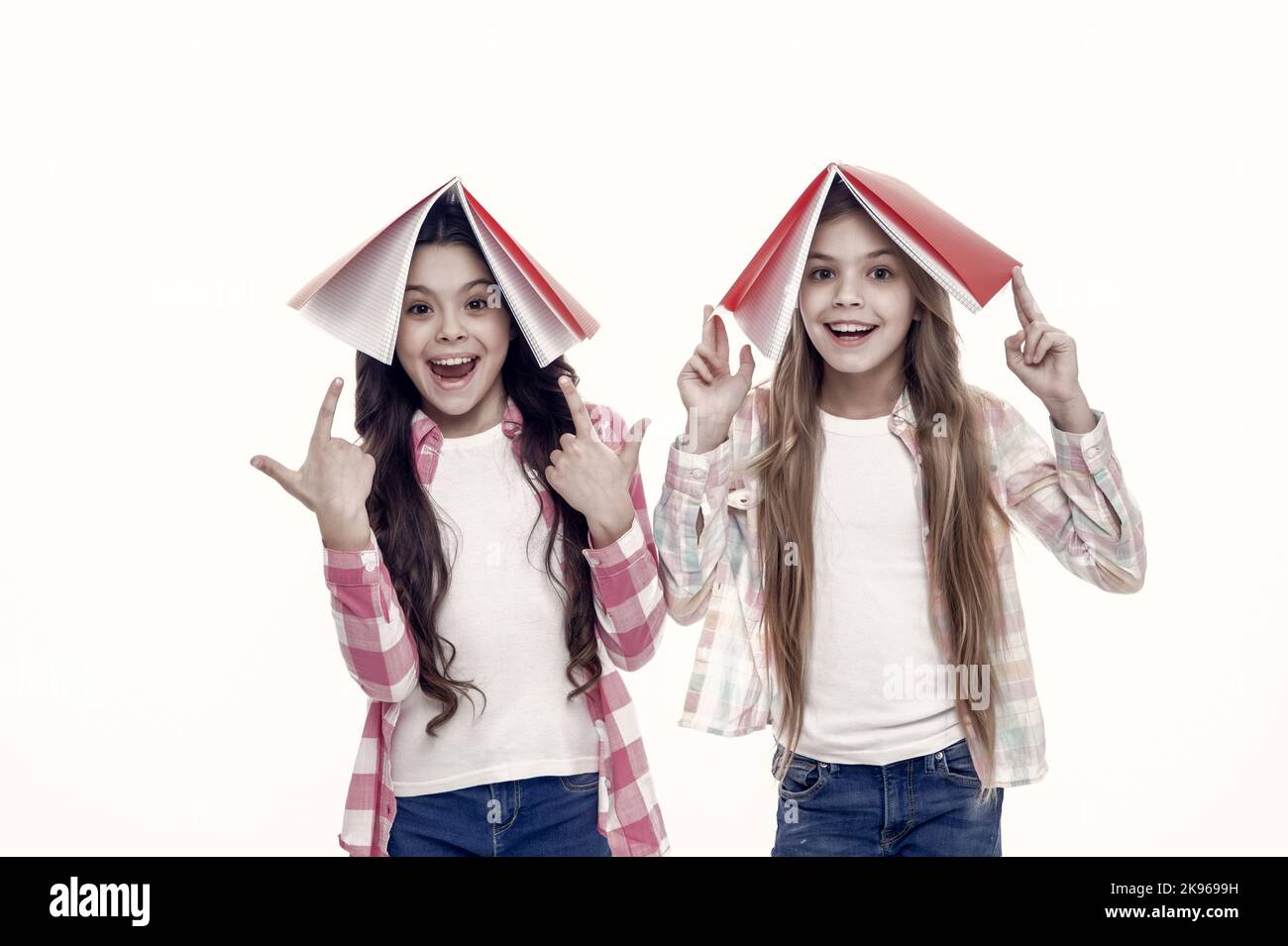Knowledge is power. Adorable little school girls holding books over ...