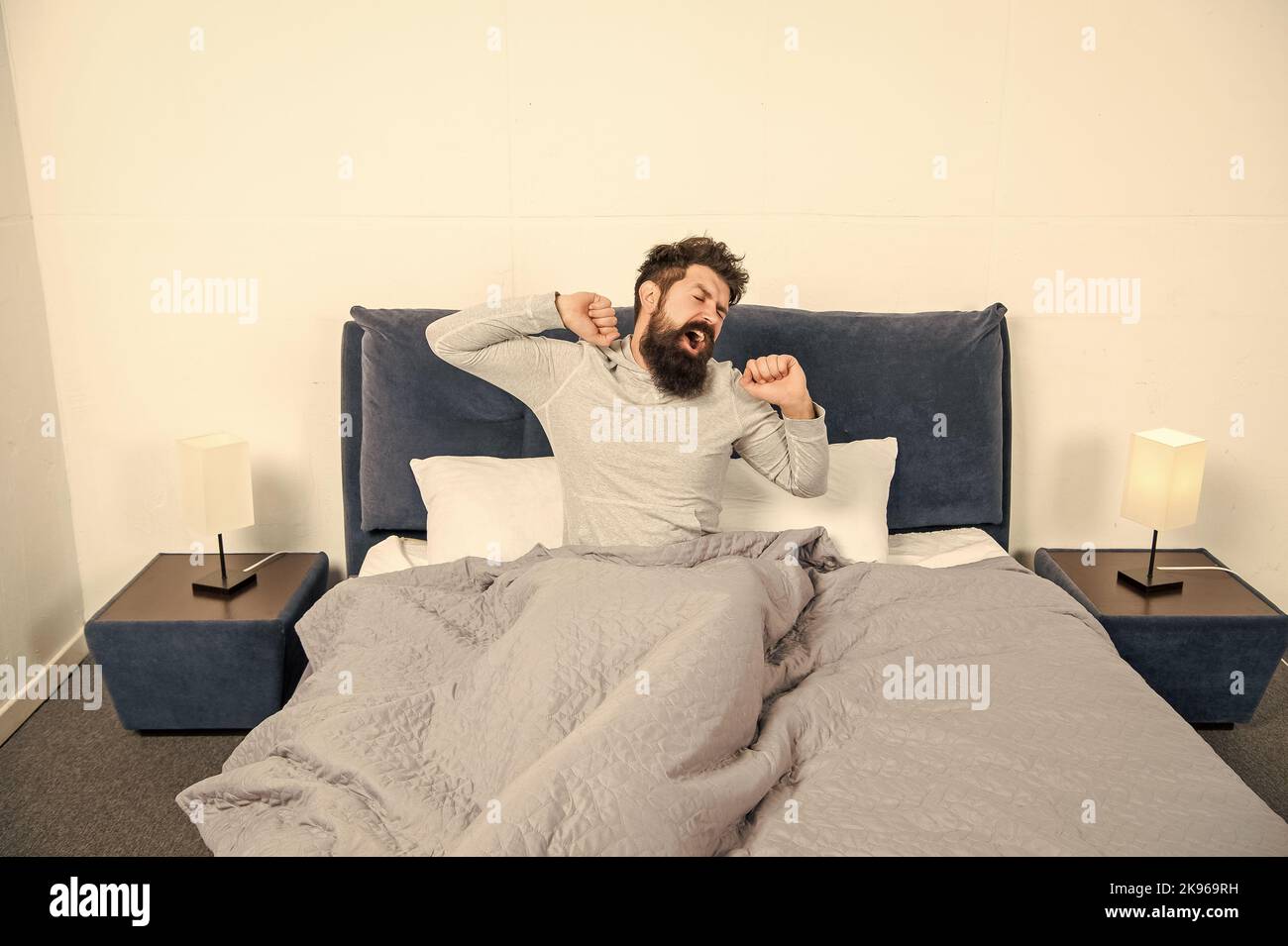 Sleepy man yawn and stretch in bed waking up after sleep, morning Stock Photo - Alamy