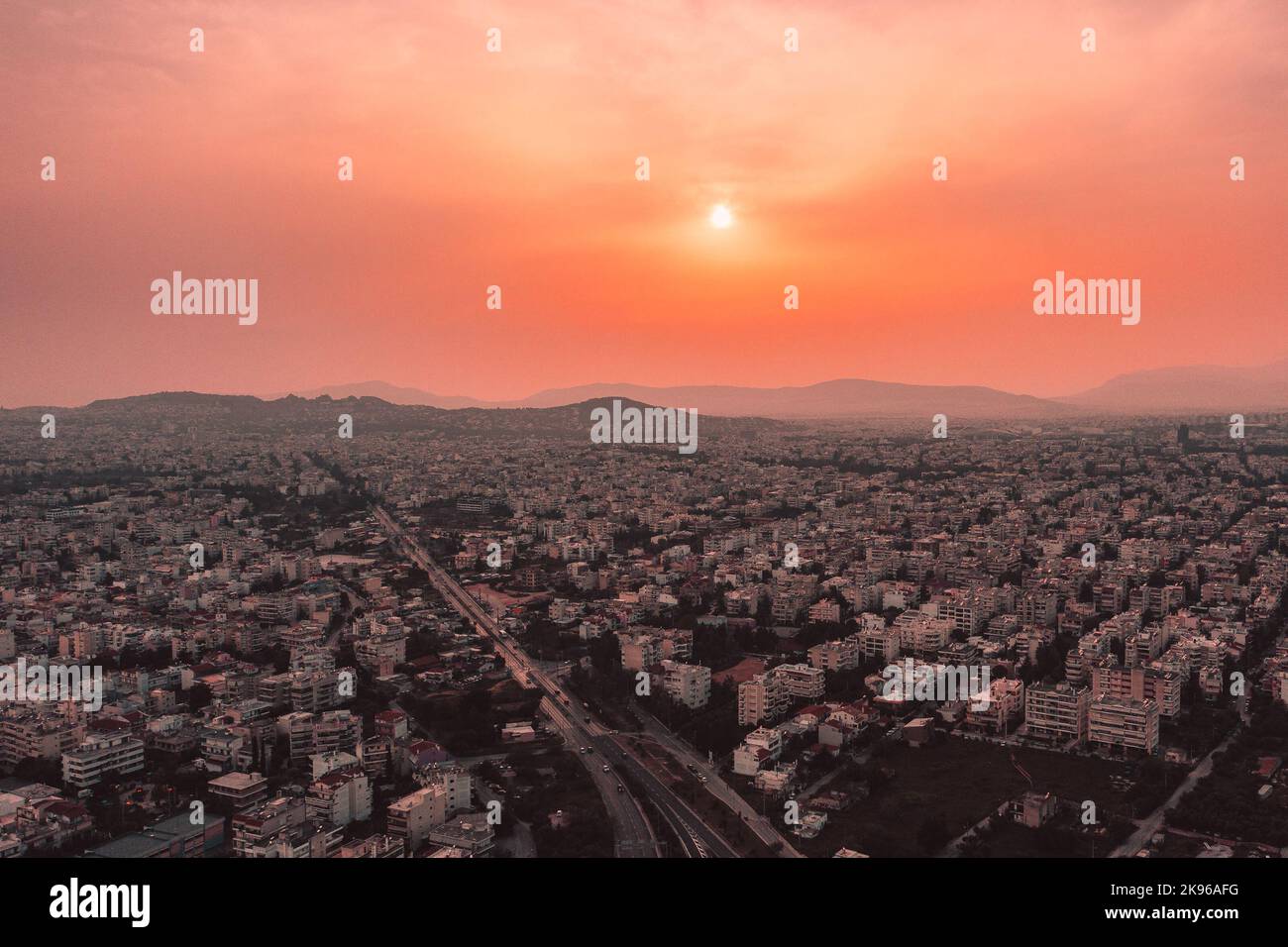 An aerial view of the skyline of buildings under a sunset sky near ...