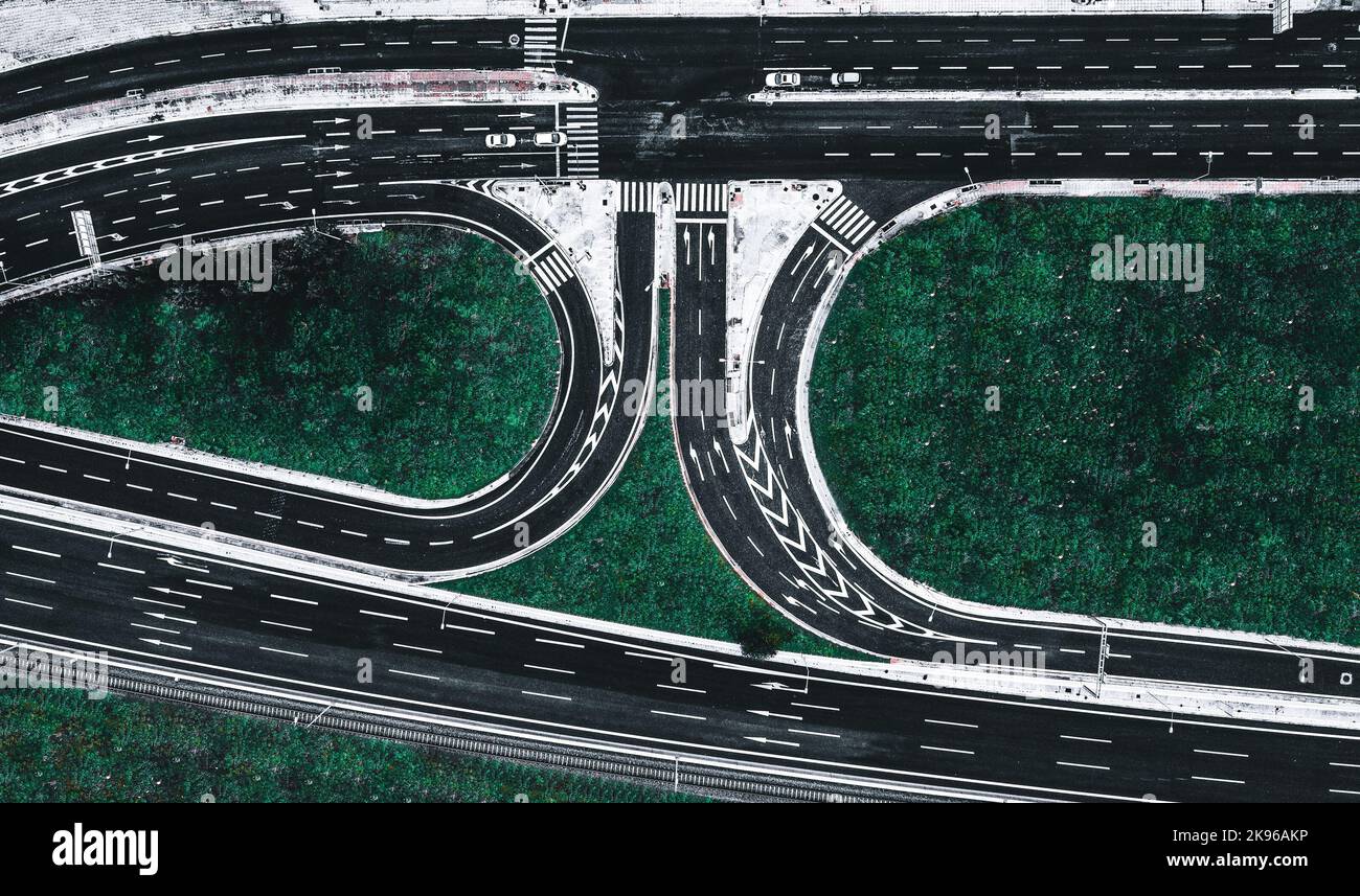 An aerial view of an empty intersection with roads and green trees in ...