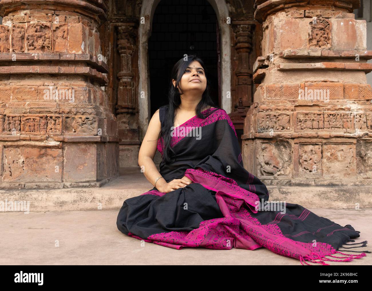 A pretty Indian woman in saree near a terracotta temple of West Bengal ...