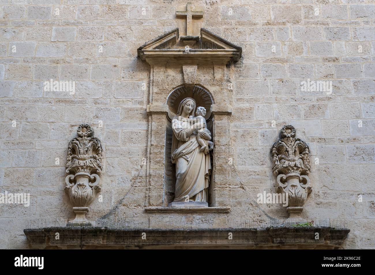 Facade of the ancient dominican convent with stone statue of the Virgin ...