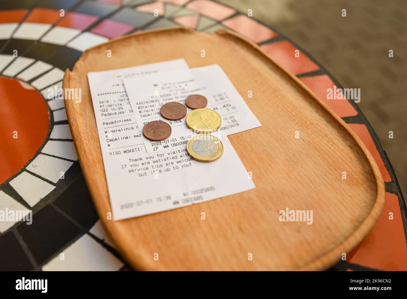 wooden tray in a cafe with an invoice for payment and change in euro ...