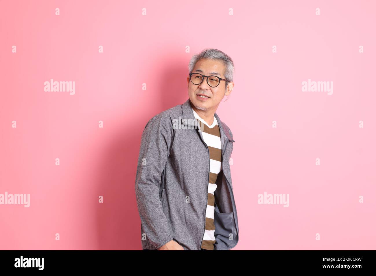 The 40s adult Asian man stnading on the pink background with casual ...