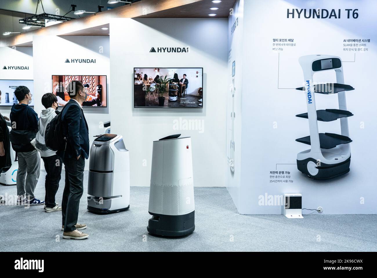 Visitors look at service robots of Hyundai Robotics at the event ...