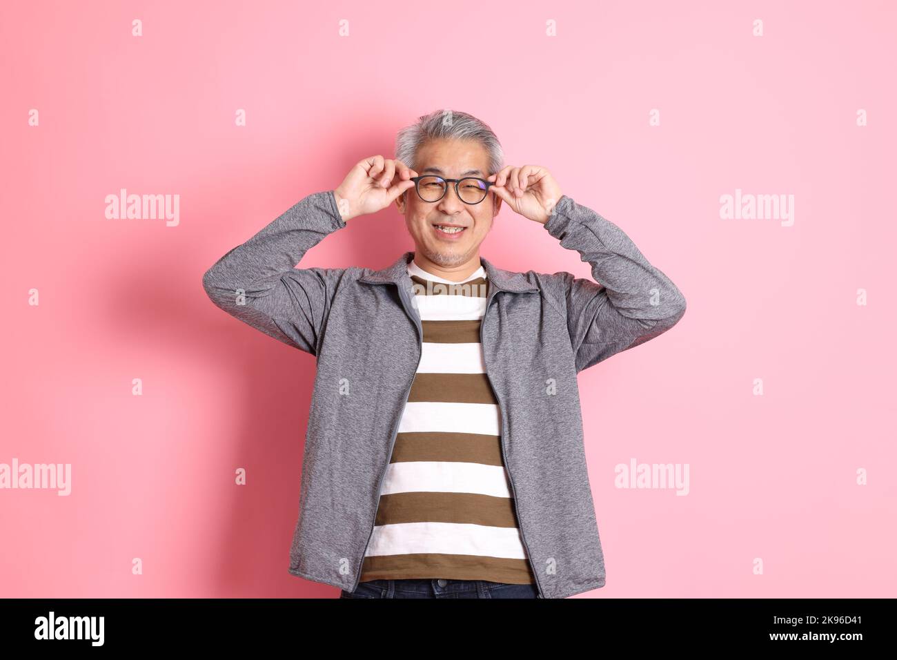 The 40s adult Asian man stnading on the pink background with casual ...