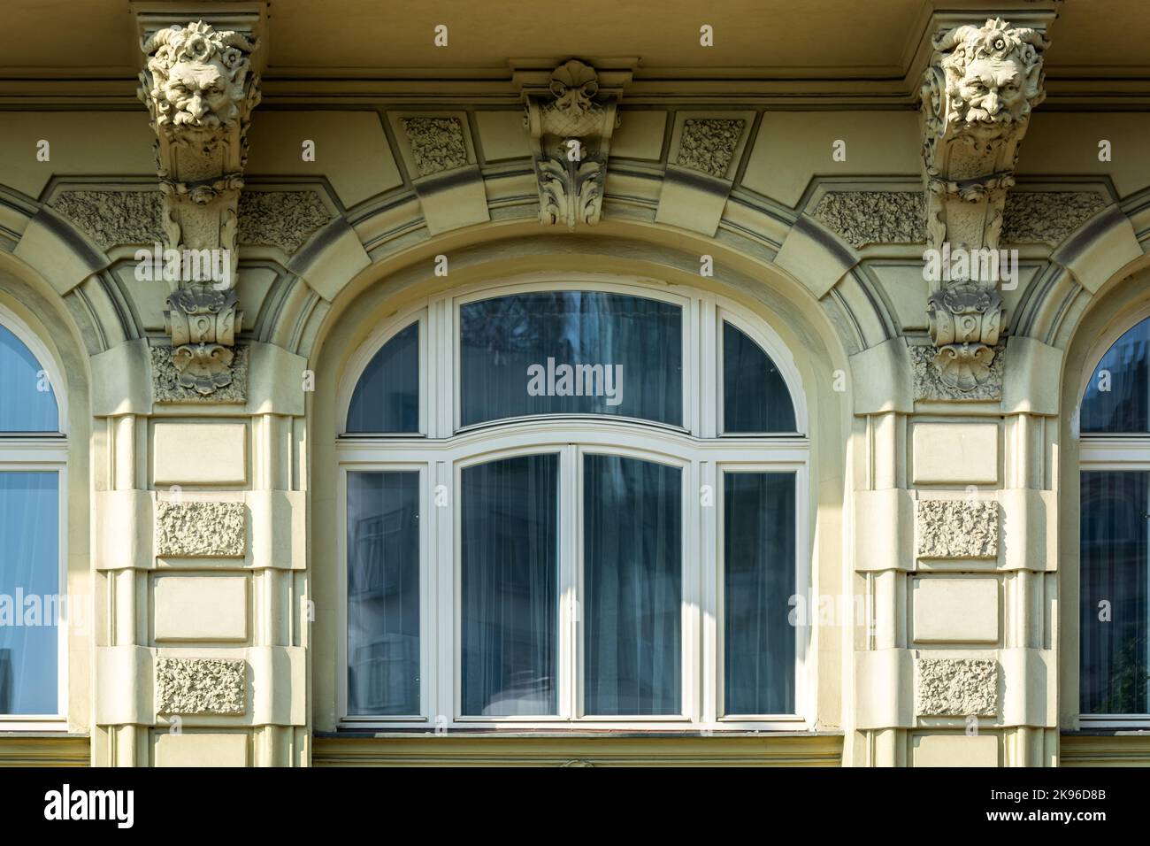 Arched window with a white frame sculpture and stucco reflection of ...