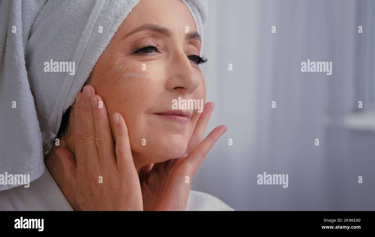 Old senior mature Caucasian woman touching massage female wrinkled face ...