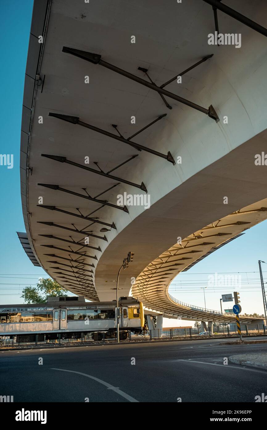 A vertical shot of a train under the bridge in Alges, Lisbon Stock ...