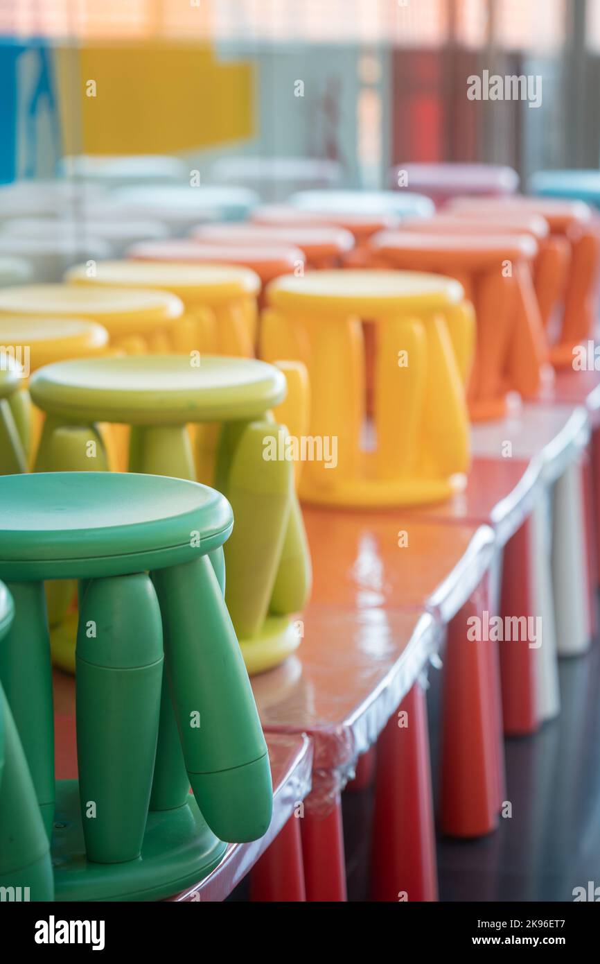 A vertical of a row of colorful stools stacked on top of each other ...