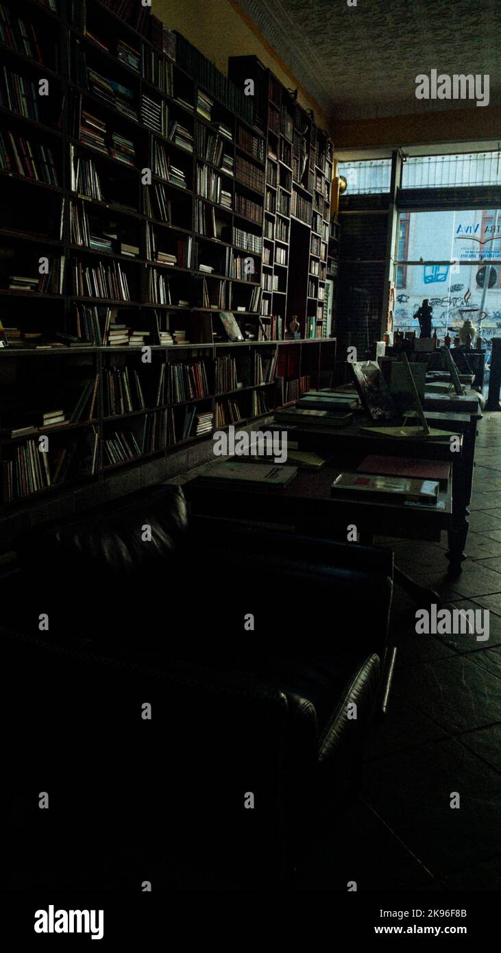 The vertical view of tables in front of the bookshelf on the wall in a ...