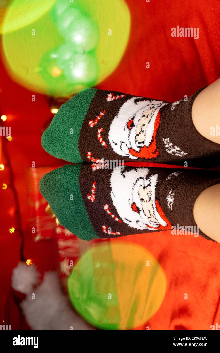 Women's feet in warm Christmas socks with Santa Claus close-up Stock ...