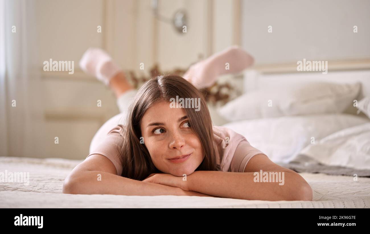 A beautiful Caucasian woman daydreaming while lying on her bed Stock ...
