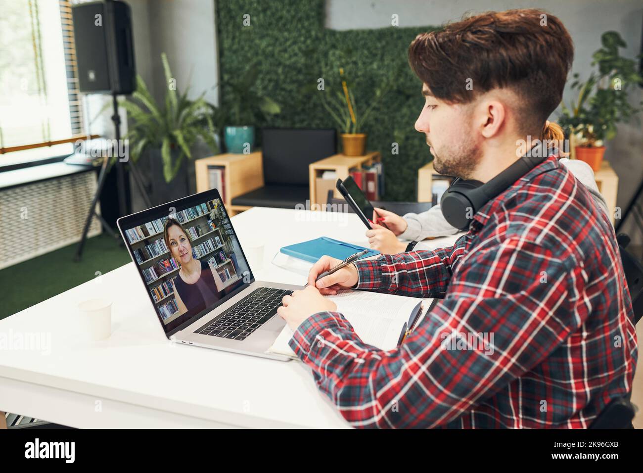 Students learning in university library. Young man having video class ...