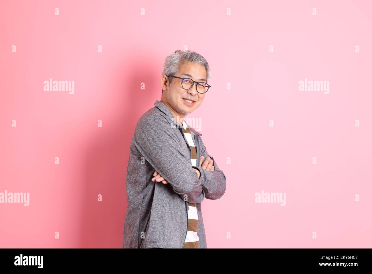 The 40s adult Asian man stnading on the pink background with casual ...