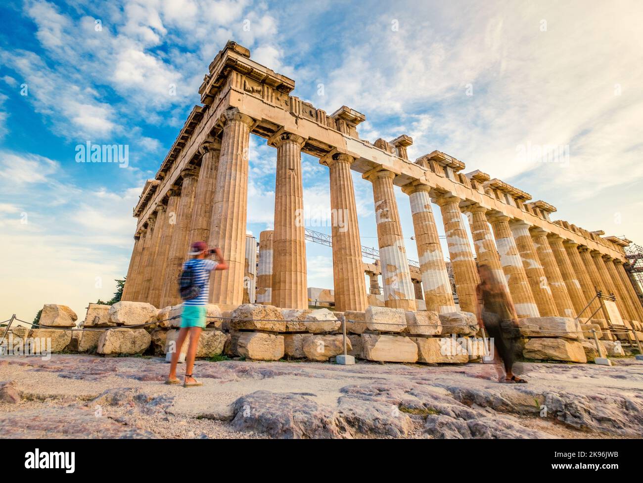 Low down shot of tourists photographing ruins of Parthenon marble columns, motion blur ...